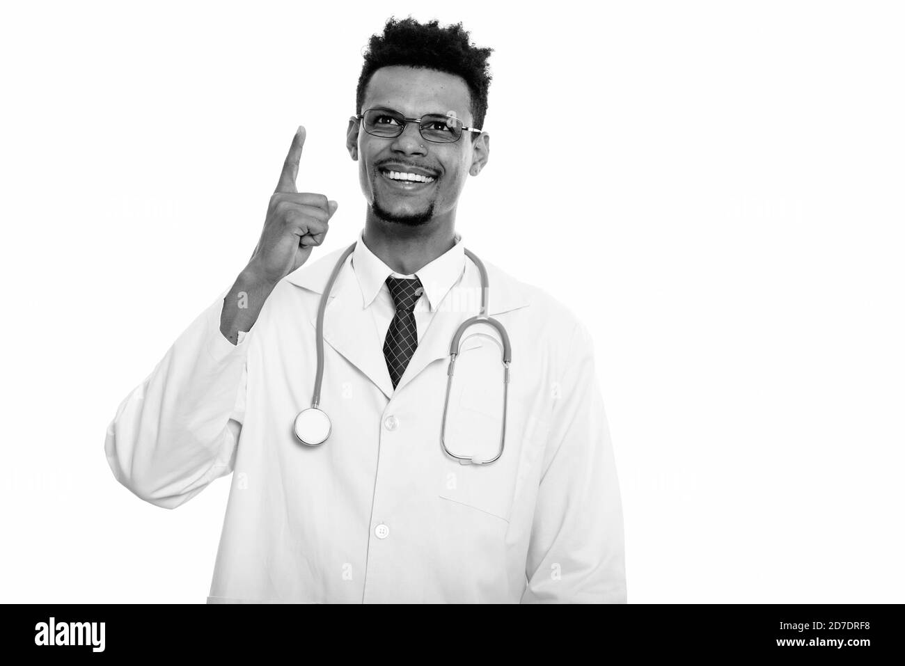 Thoughtful happy African man doctor smiling while pointing finger up ...