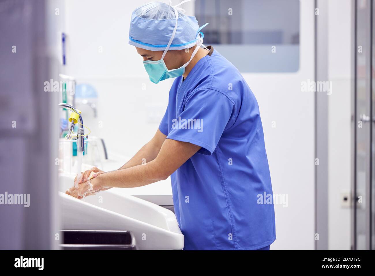 Male Surgeon Wearing Scrubs Washing Hands Before Operation In Hospital ...