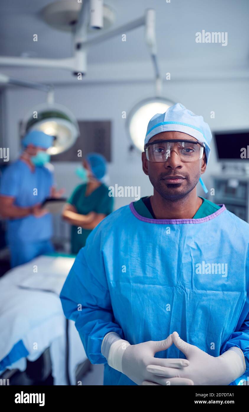 Portrait Of Male Surgeon Wearing Scrubs And Protective Glasses In ...