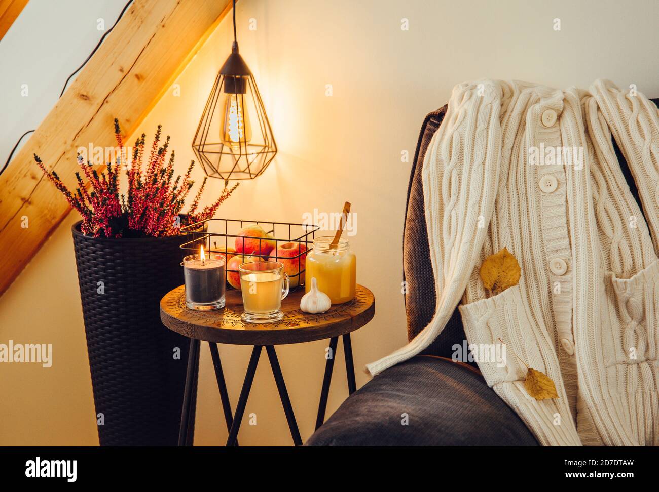 Cozy sick day at home. Table with hot tea cup, garlic and jar of honey ...