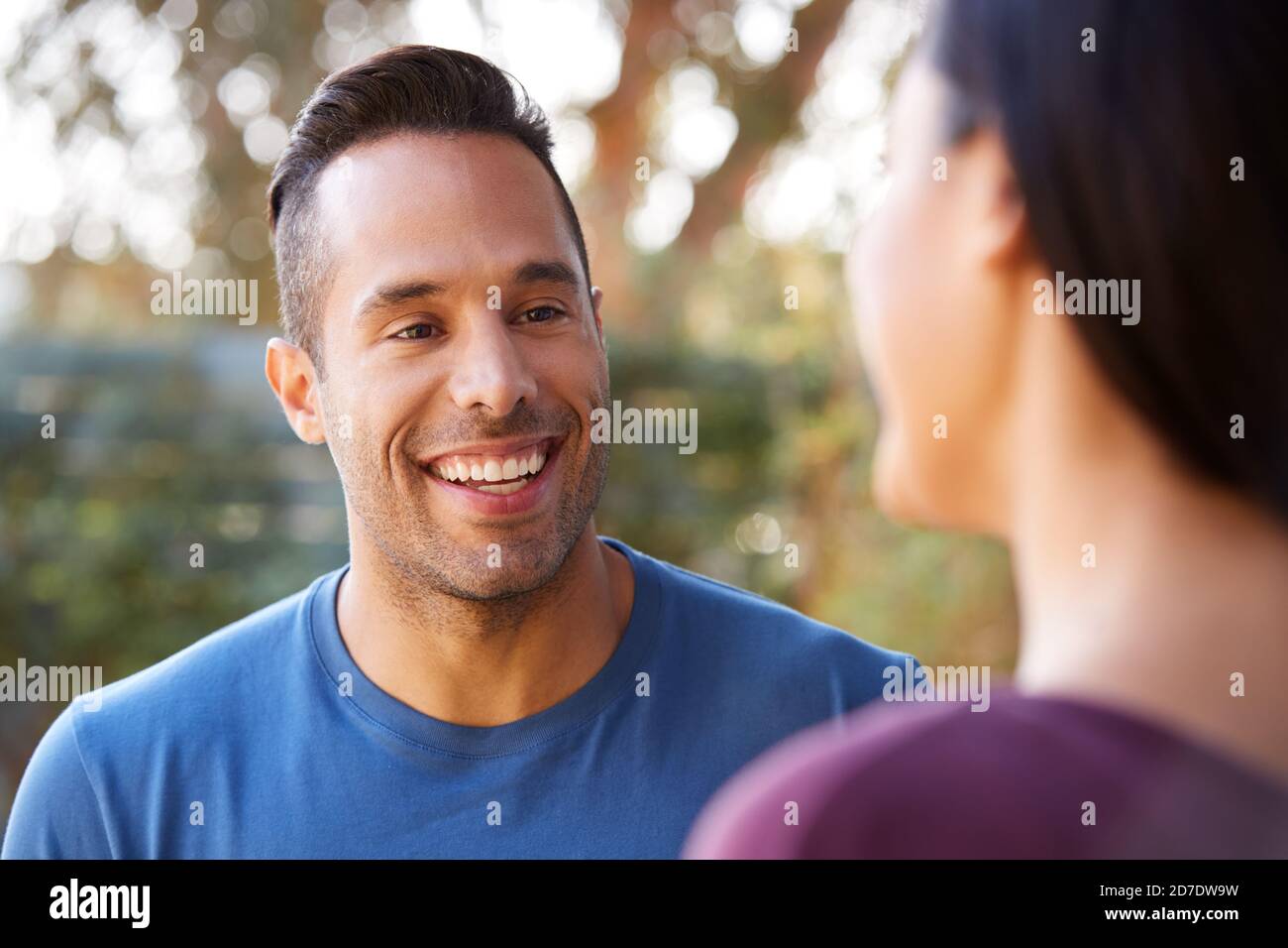 Smiling Hispanic Couple Talking And Laughing In Garden At Home Stock ...