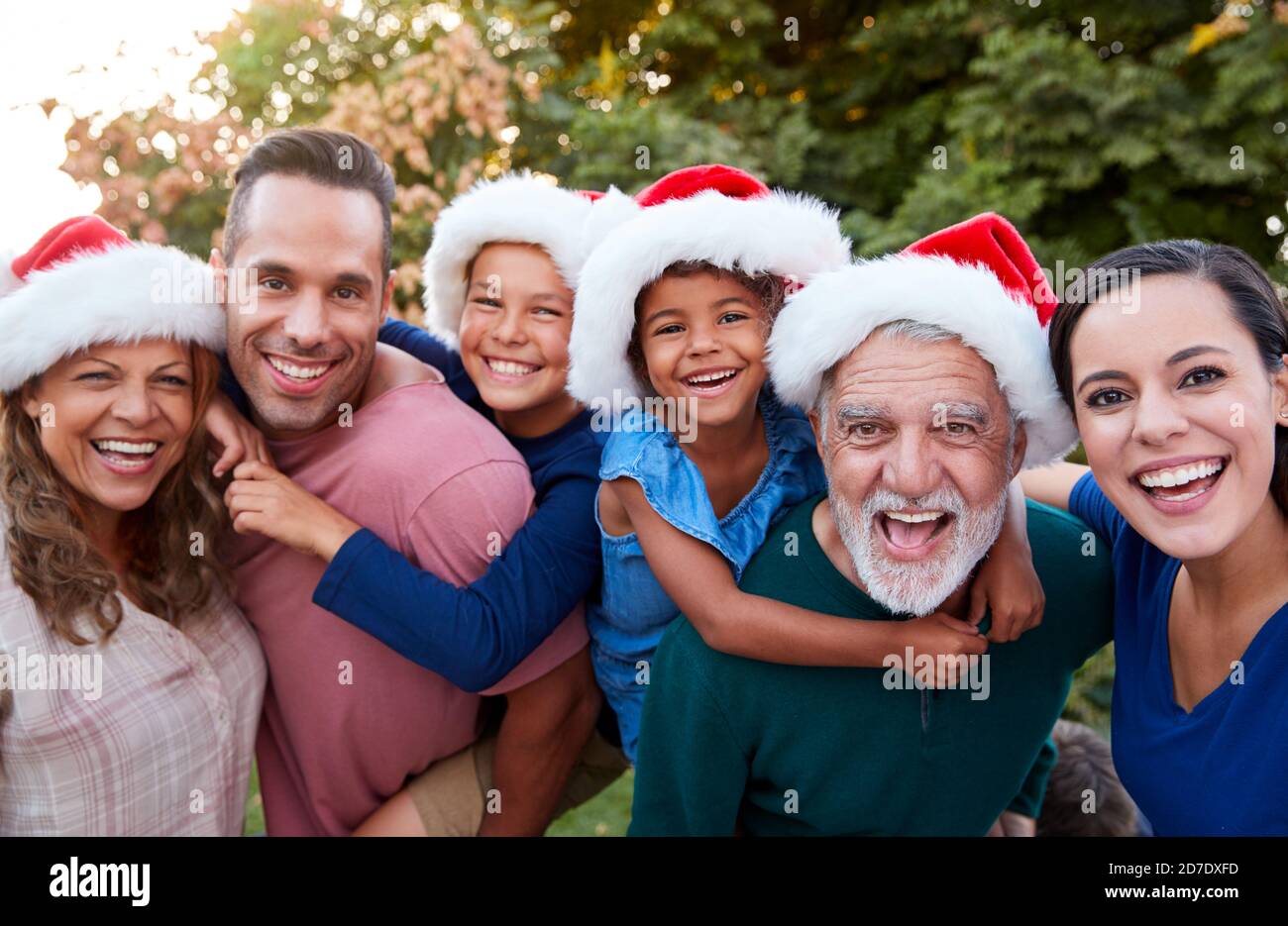 Portrait Of Multi-Generation Hispanic Family Relaxing In Garden At Home ...
