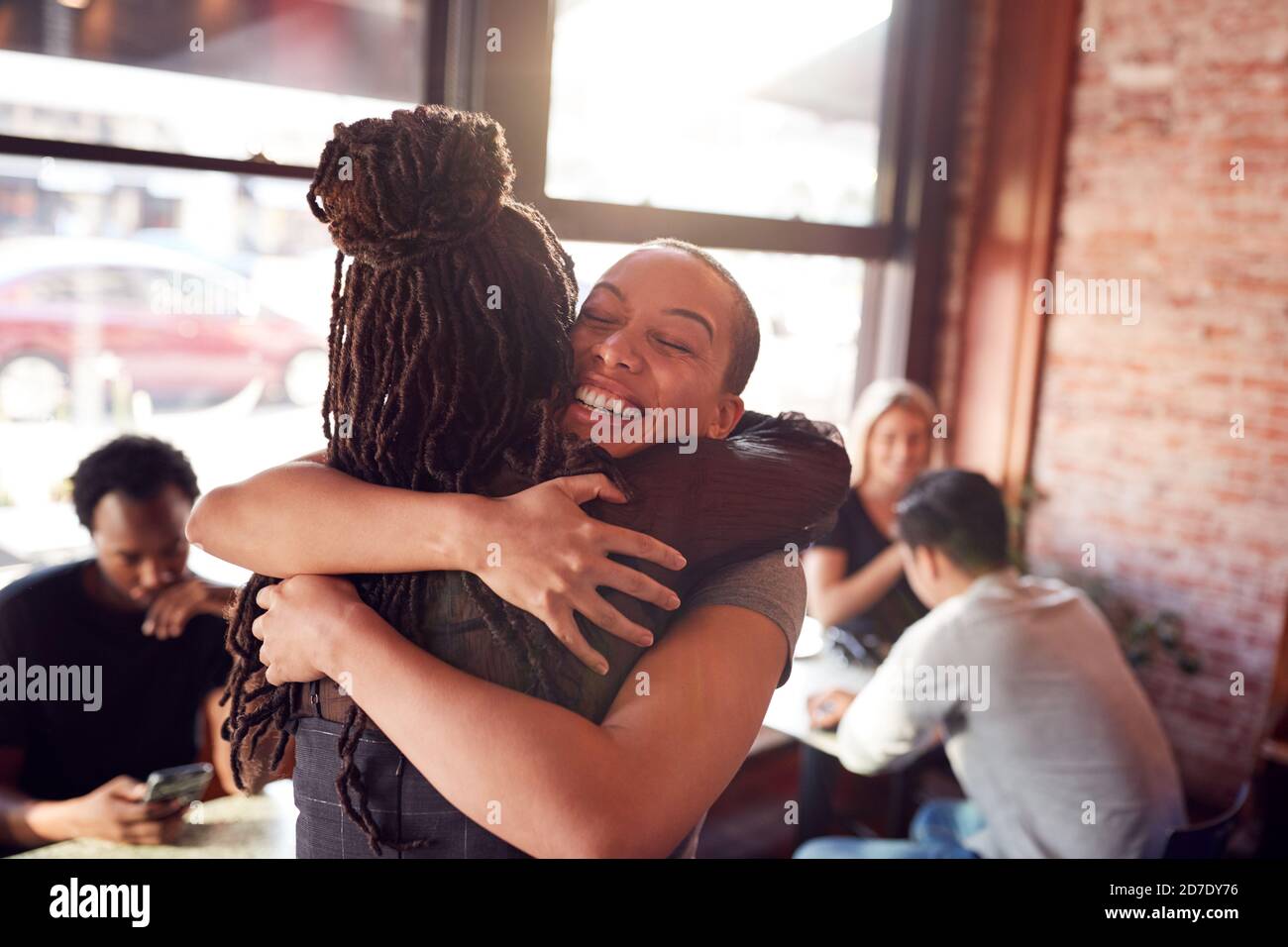 Two friends hug indoors hi-res stock photography and images - Alamy