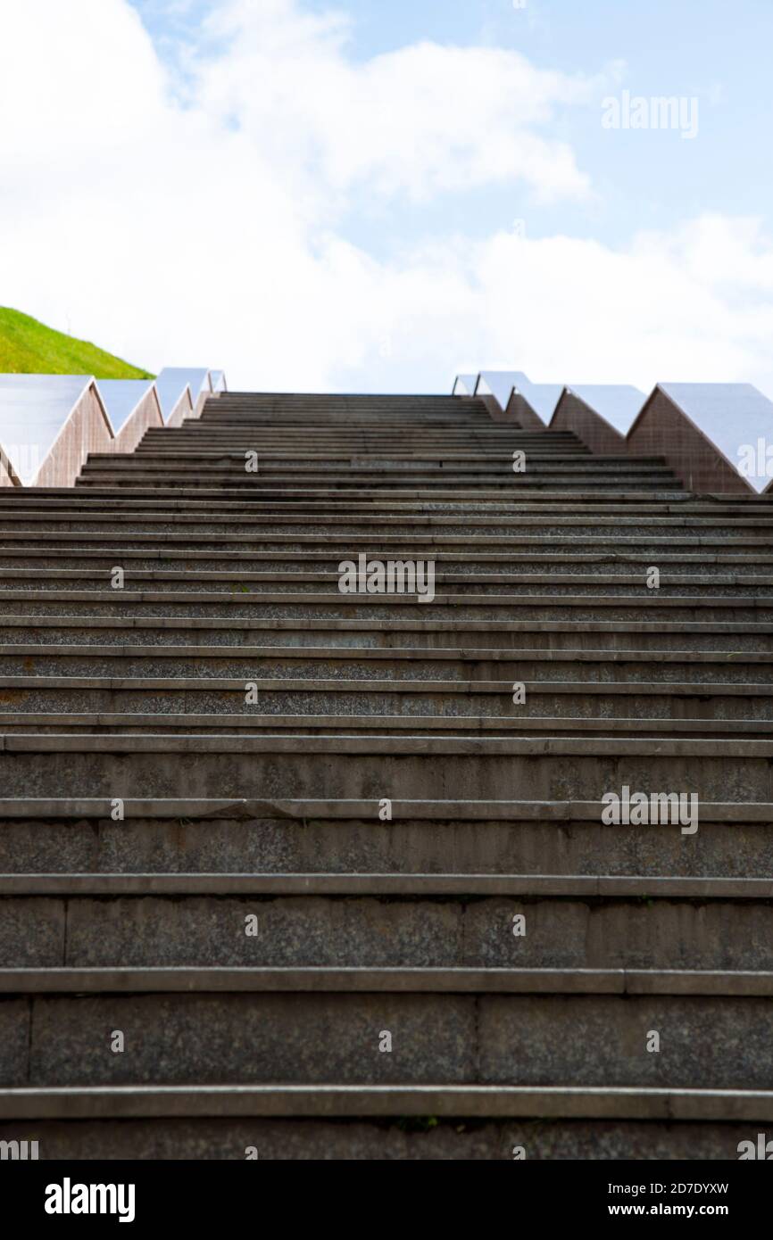 Concept photo of a staircase in a bright cloudy sky, side view. A large ...