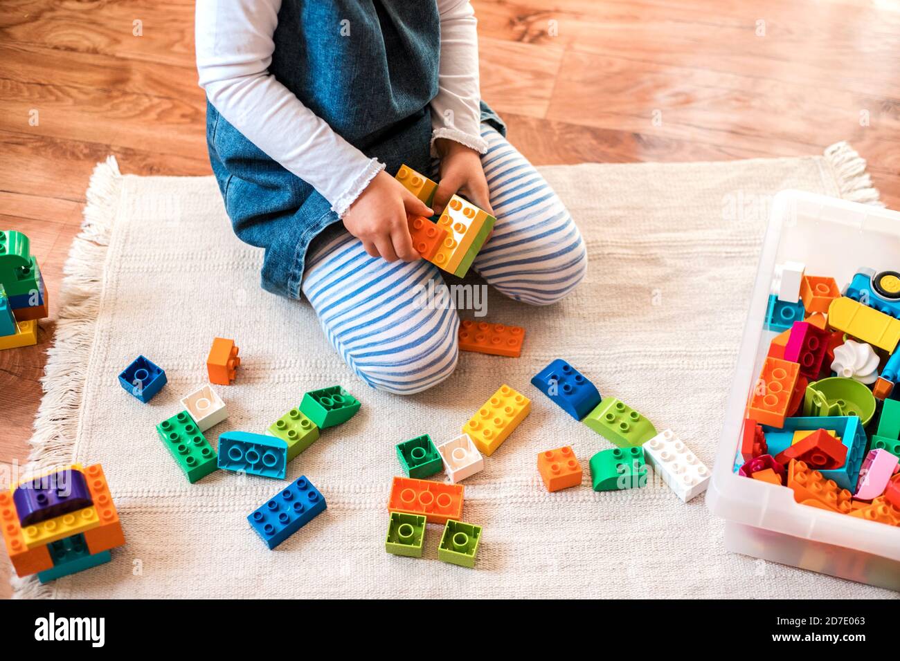Little girl playing with her colorful blocks Stock Photo - Alamy