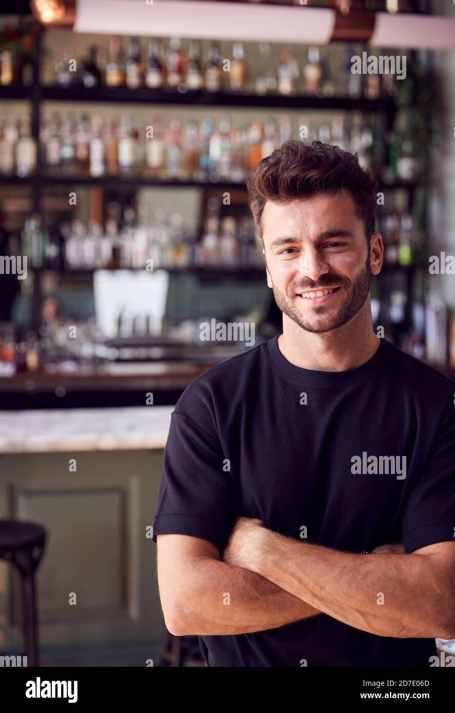 Portrait Of Confident Male Owner Of Restaurant Bar Standing By Counter ...