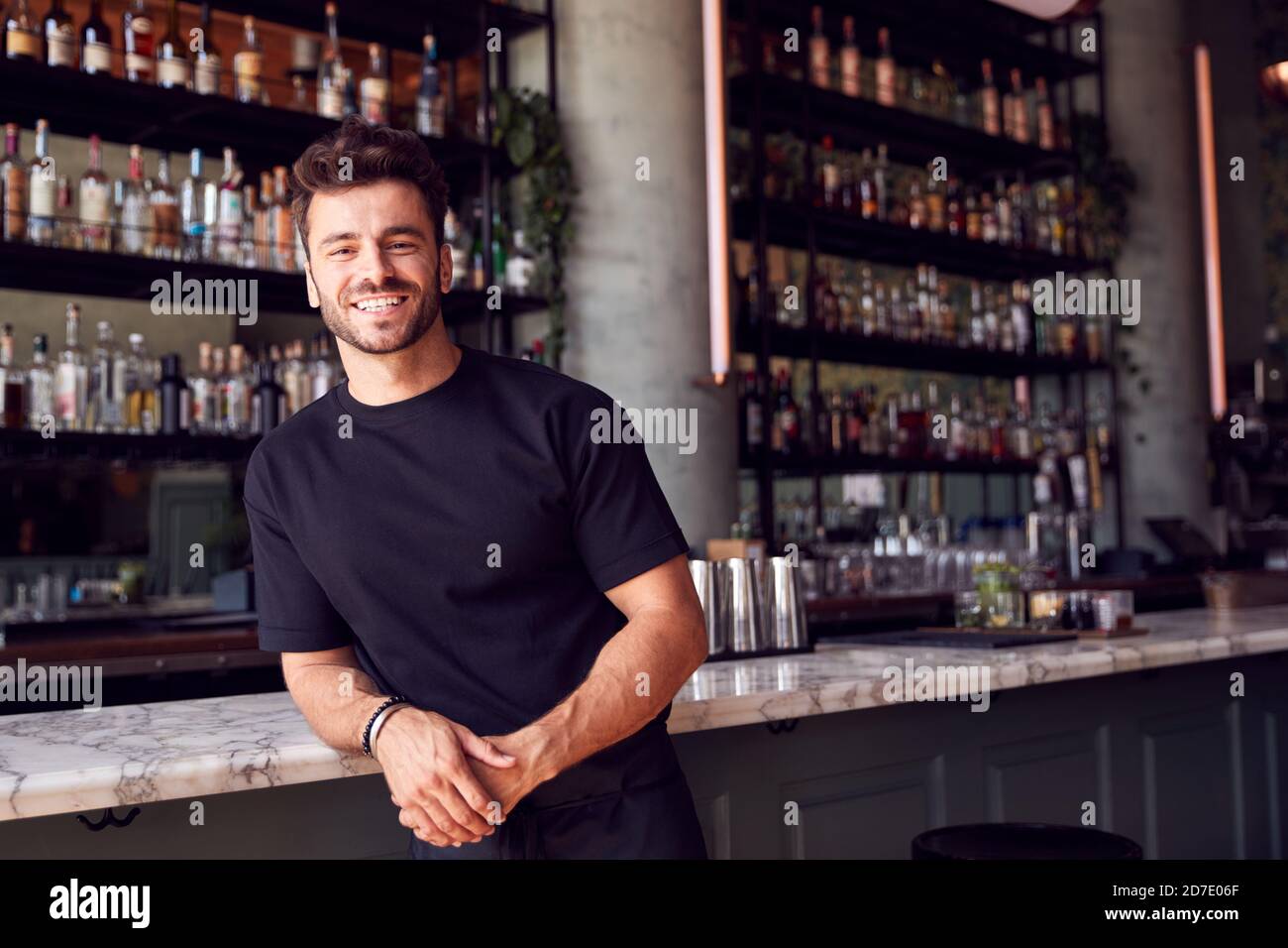 Portrait Of Confident Male Owner Of Restaurant Bar Leaning Against ...