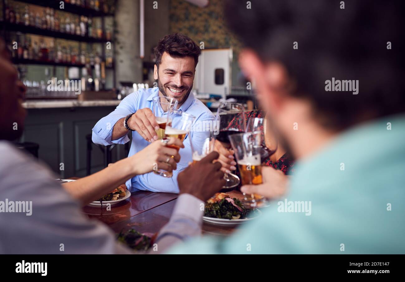 Group Of Friends Meeting In Restaurant Celebrating And Making A Toast ...