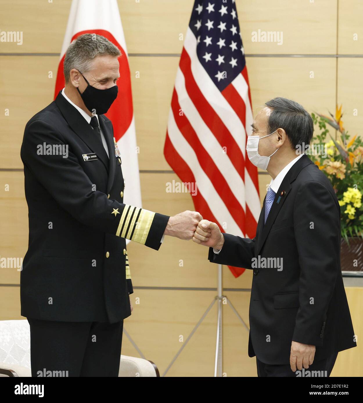 Japanese Prime Minister Yoshihide Suga (R) bumps fist with Adm. Philip ...