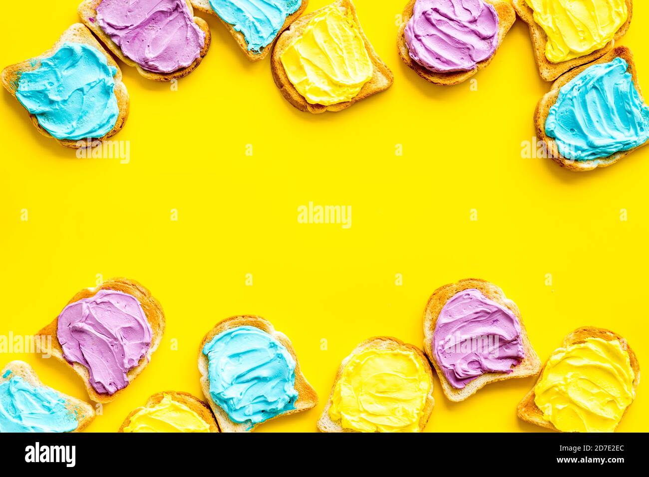 Funny toasted bread with colored cheese spread. Overhead view Stock ...
