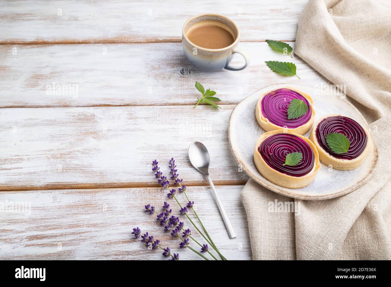 Sweet tartlets with jelly and milk cream with cup of coffee on a white ...