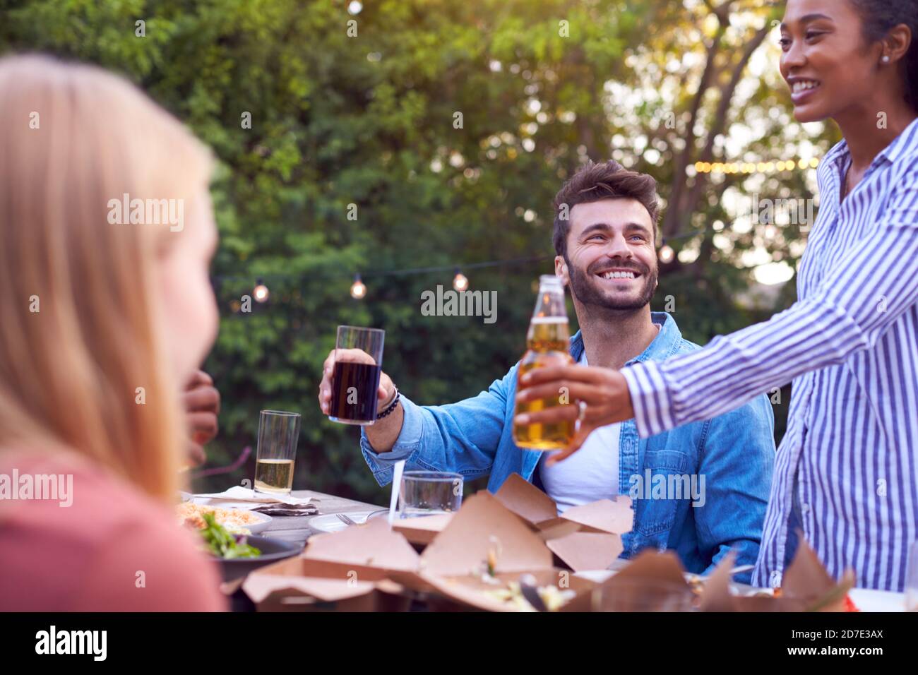 Friends Making Toast With Alcohol In Garden At Home Enjoying Summer ...