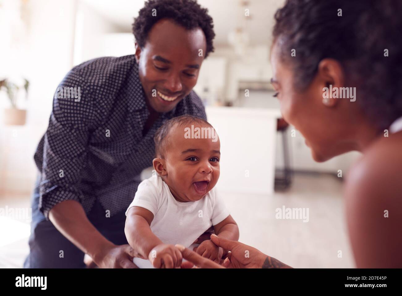 Mother helping baby daughter walk hi-res stock photography and images ...