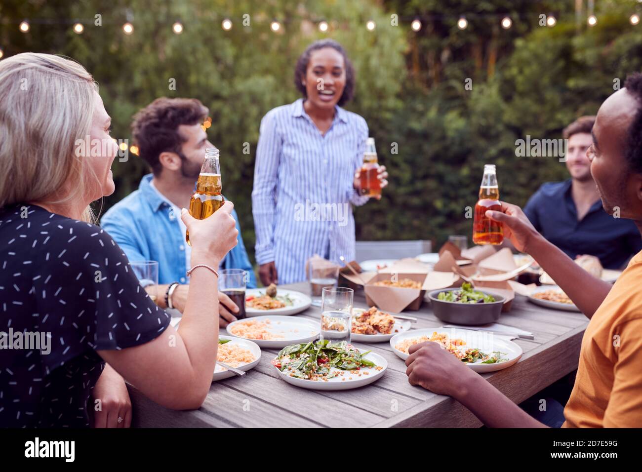 Multi-Cultural Friends At Home Around Table Making A Toast As They ...