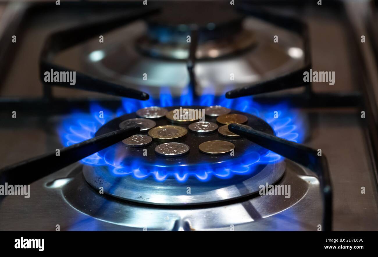 coins lie on the stove burner on which the gas is turned on Stock Photo ...