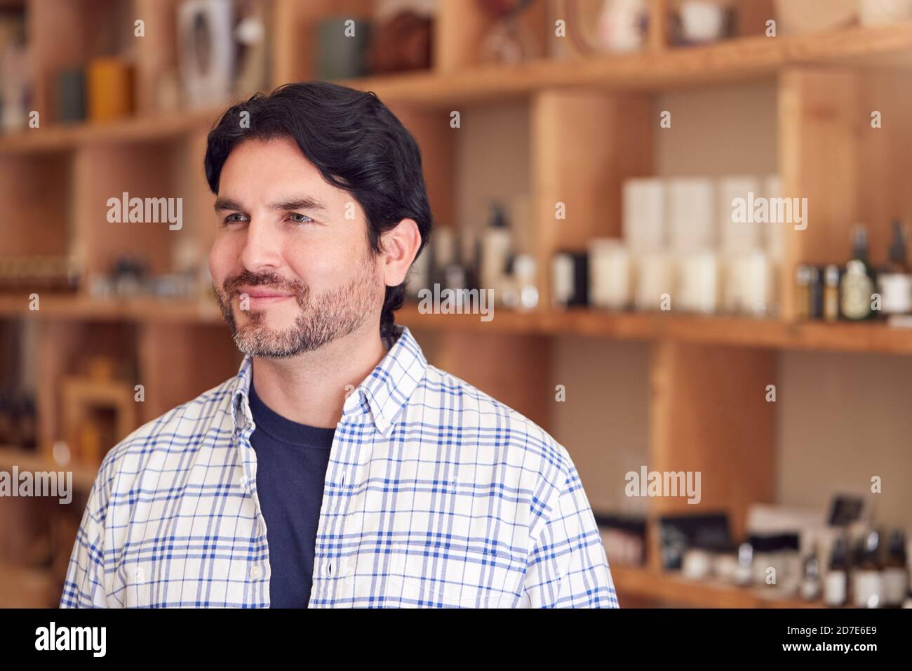 Male Owner Of Gift Store Standing In Front Of Shelves With Cosmetics ...