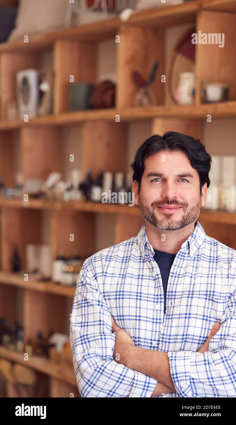 Portrait Of Male Owner Of Gift Store Standing In Front Of Shelves With ...