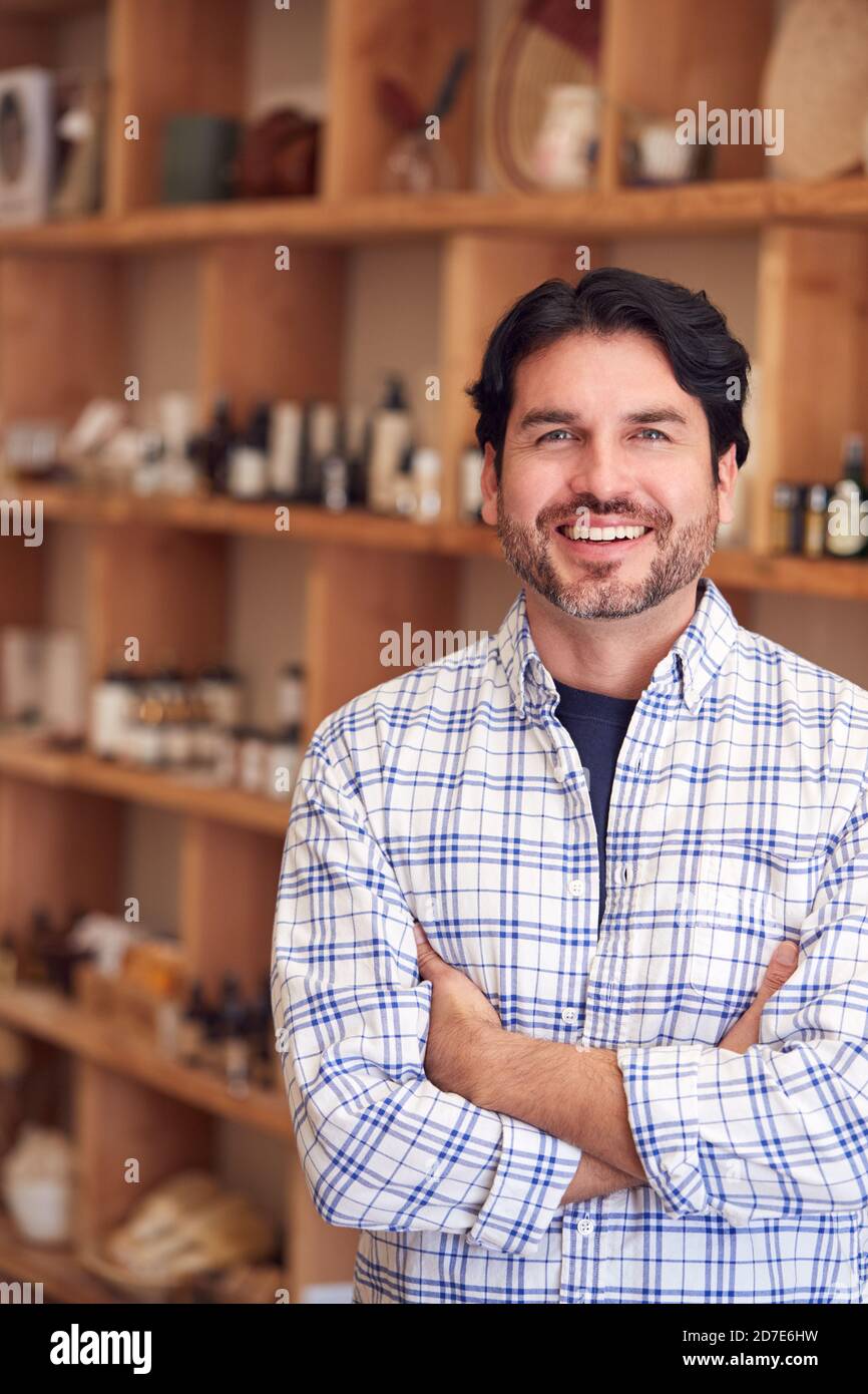Portrait Of Male Owner Of Gift Store Standing In Front Of Shelves With ...