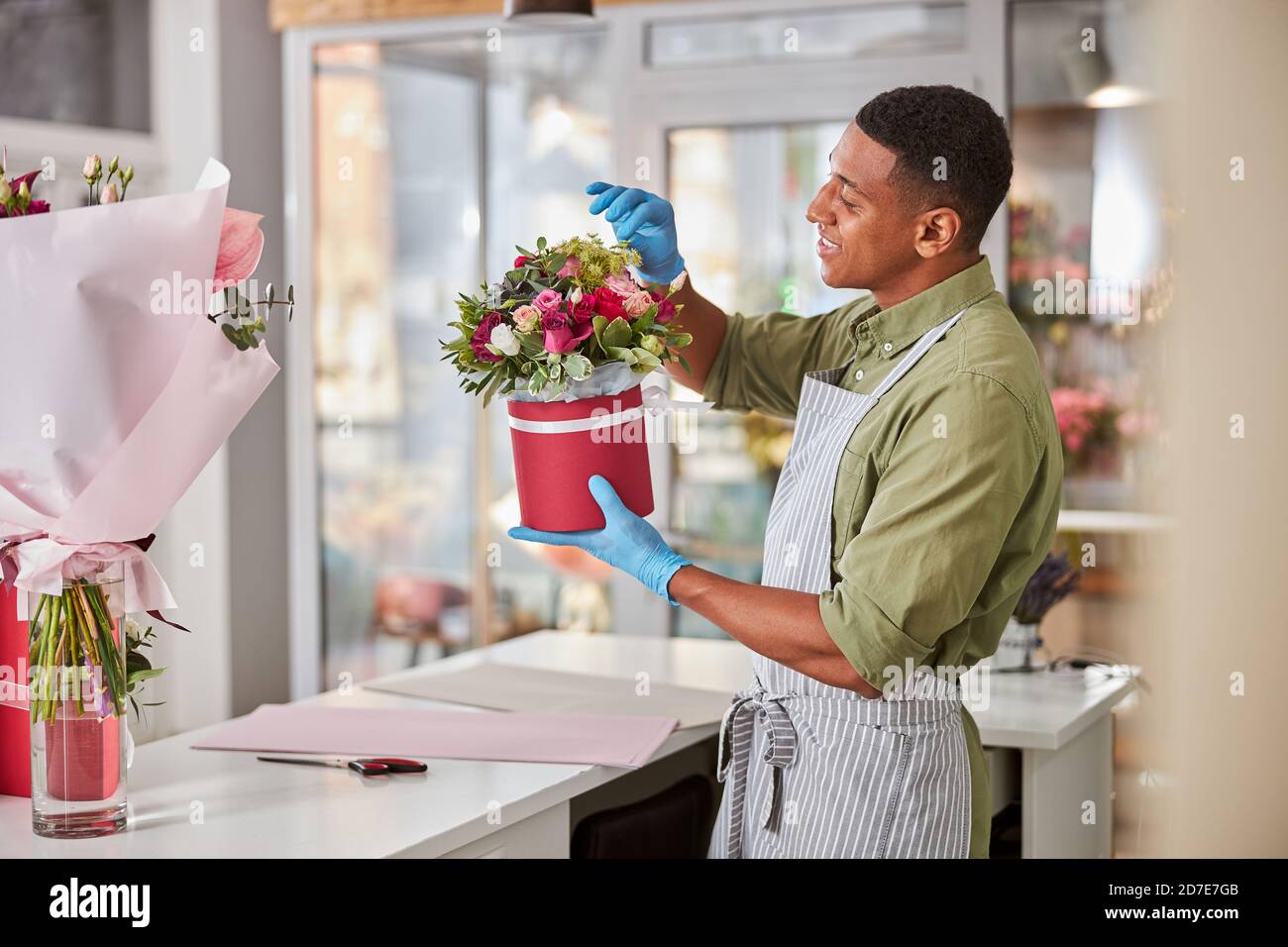 Flower store salesperson arranging roses in a pot Stock Photo - Alamy