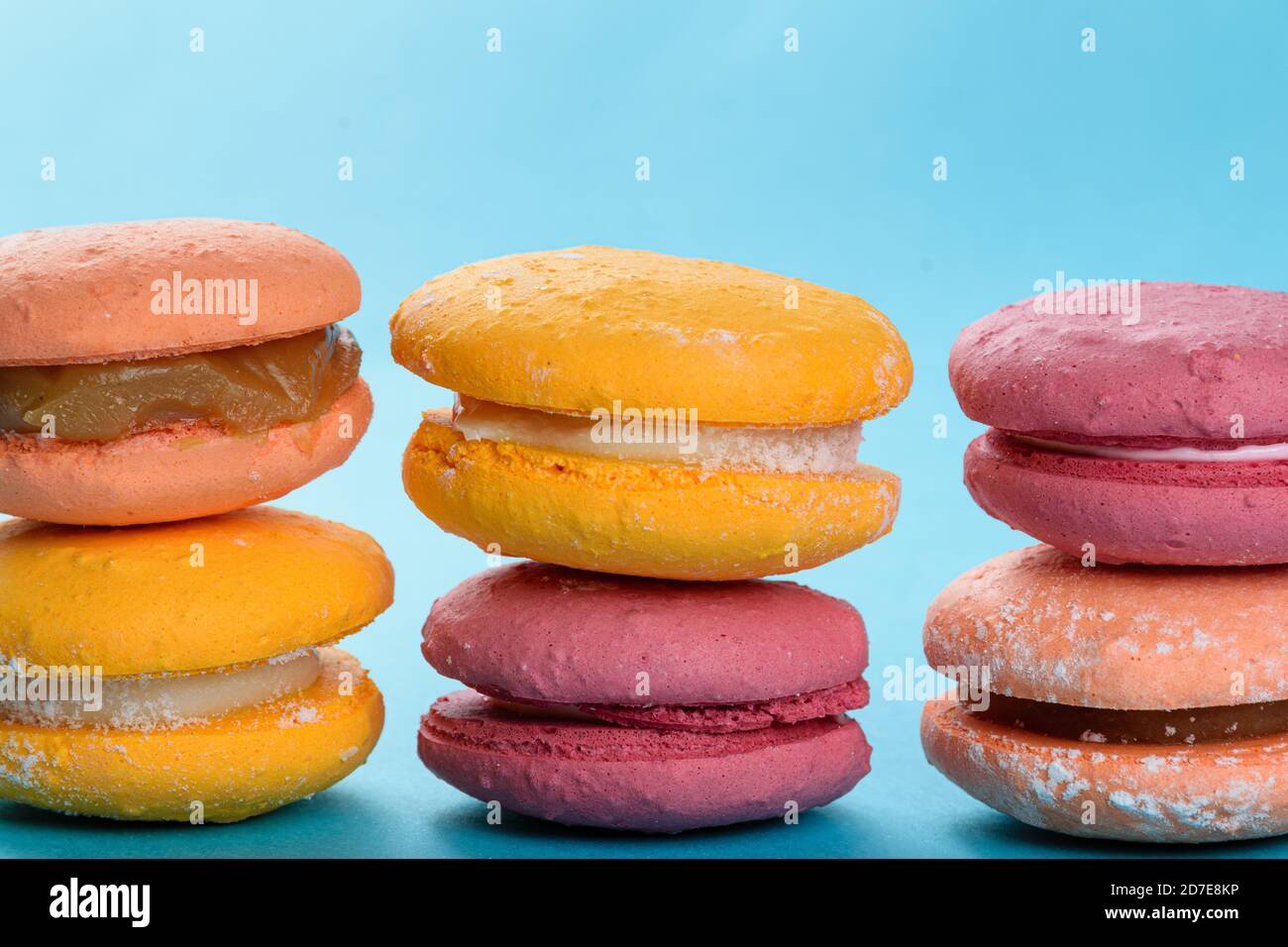 Colorful macaroons stacked on a light blue background. French sweet ...