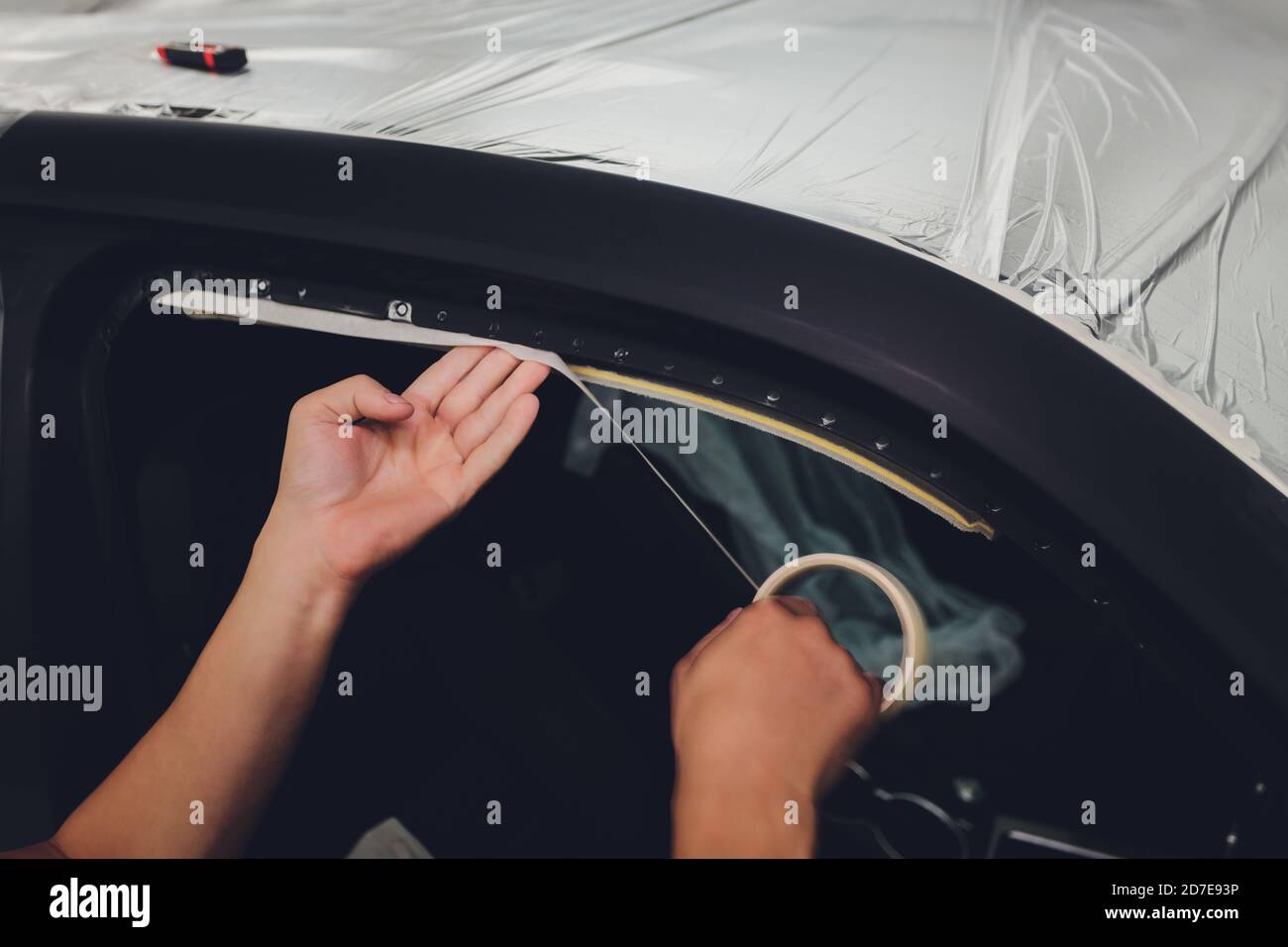Mechanic preparing a car for painting by protecting the edges Stock ...