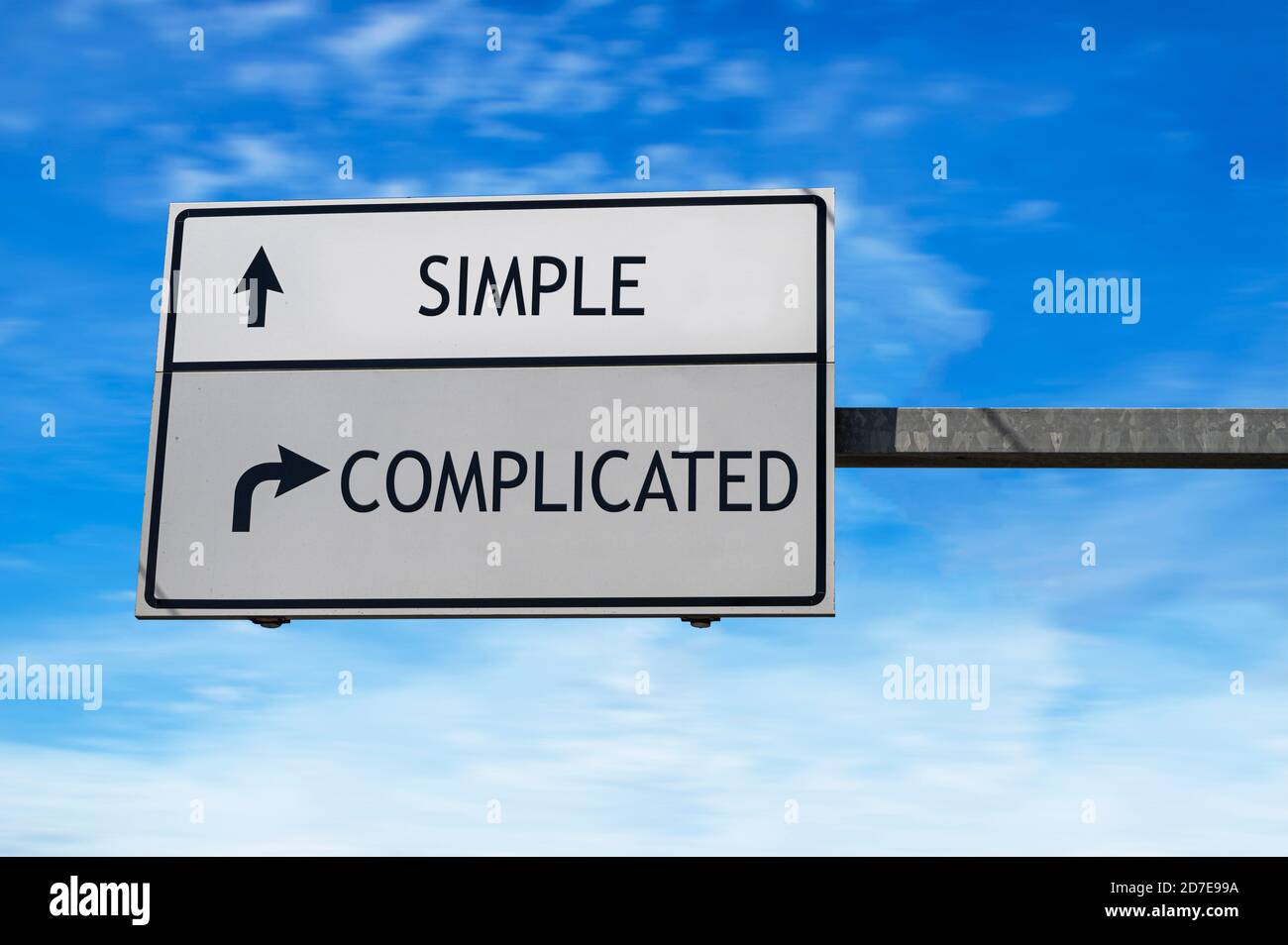 Simple versus complicated. White two street signs with arrow on metal ...