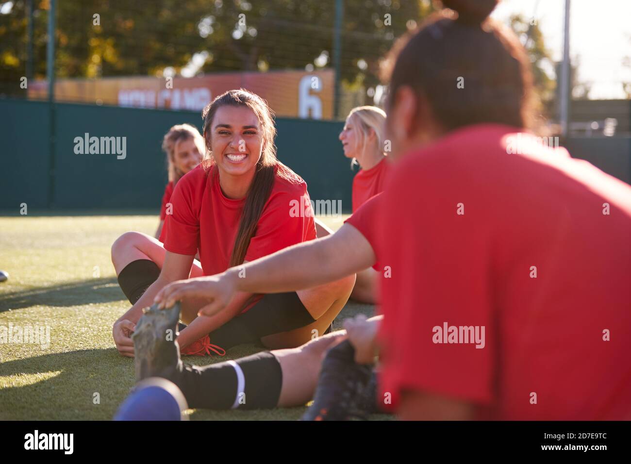 Womens Football Team Stretching Whilst Training For Soccer Match On ...
