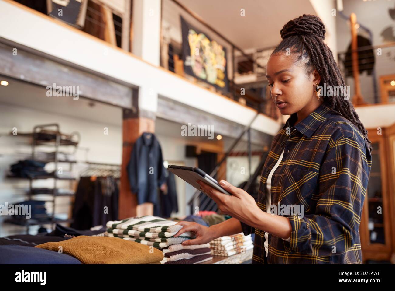 Female Owner Of Fashion Store Using Digital Tablet To Check Stock In ...
