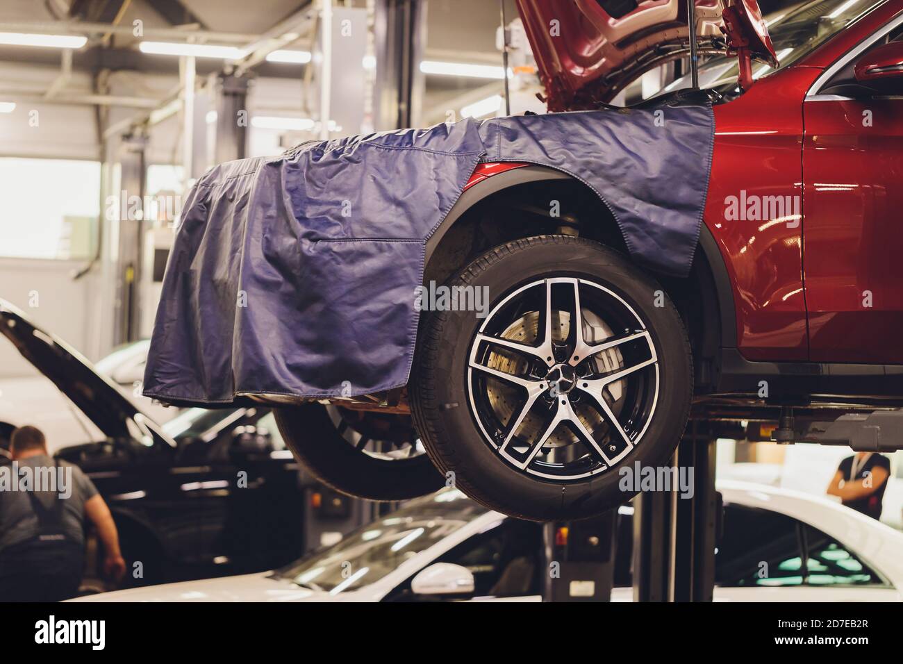 Car service - backlights of white auto in opposite lifted automobile ...