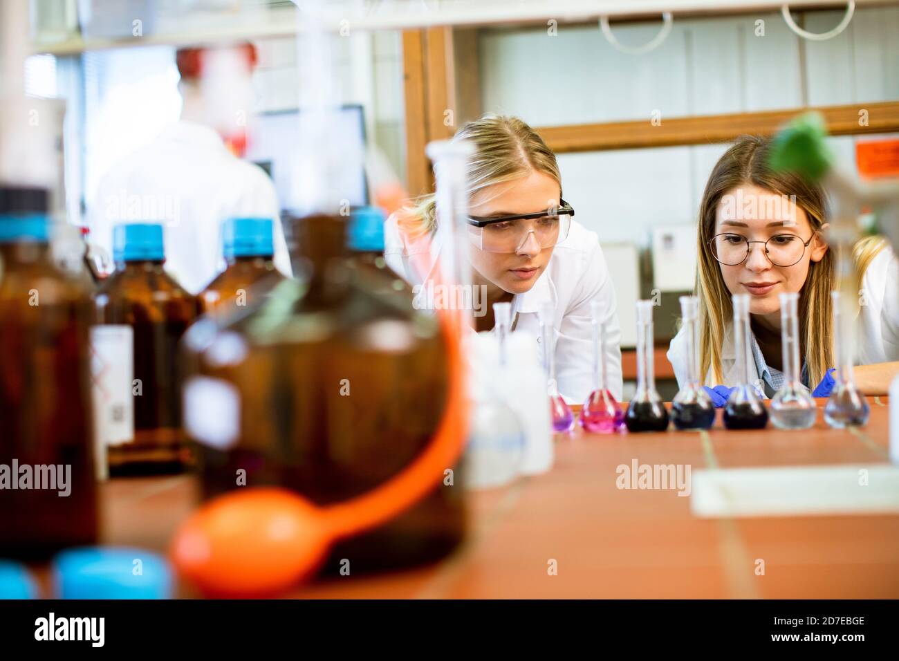 Cute female researchers in white lab coat working in the laboratory ...