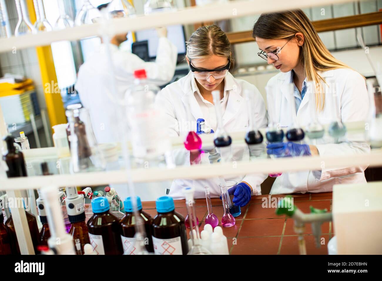 Cute female researchers in white lab coat working in the laboratory ...