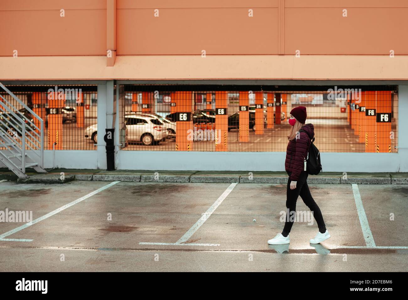 Woman with mask walking next to the garage Stock Photo - Alamy