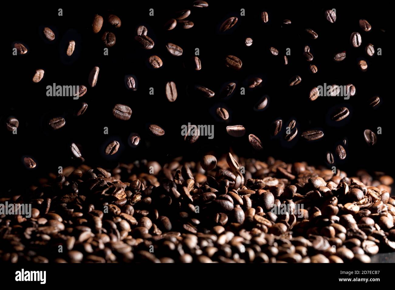 Flying coffee beans isolated on black background. Roasted coffee grains ...