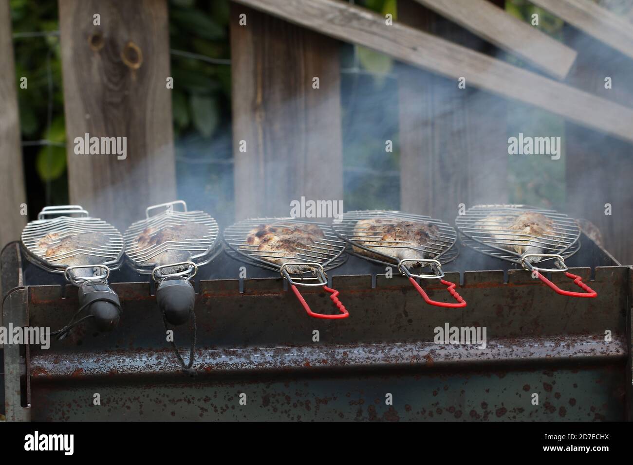 Cooking of salted fish on a grill stove Stock Photo - Alamy