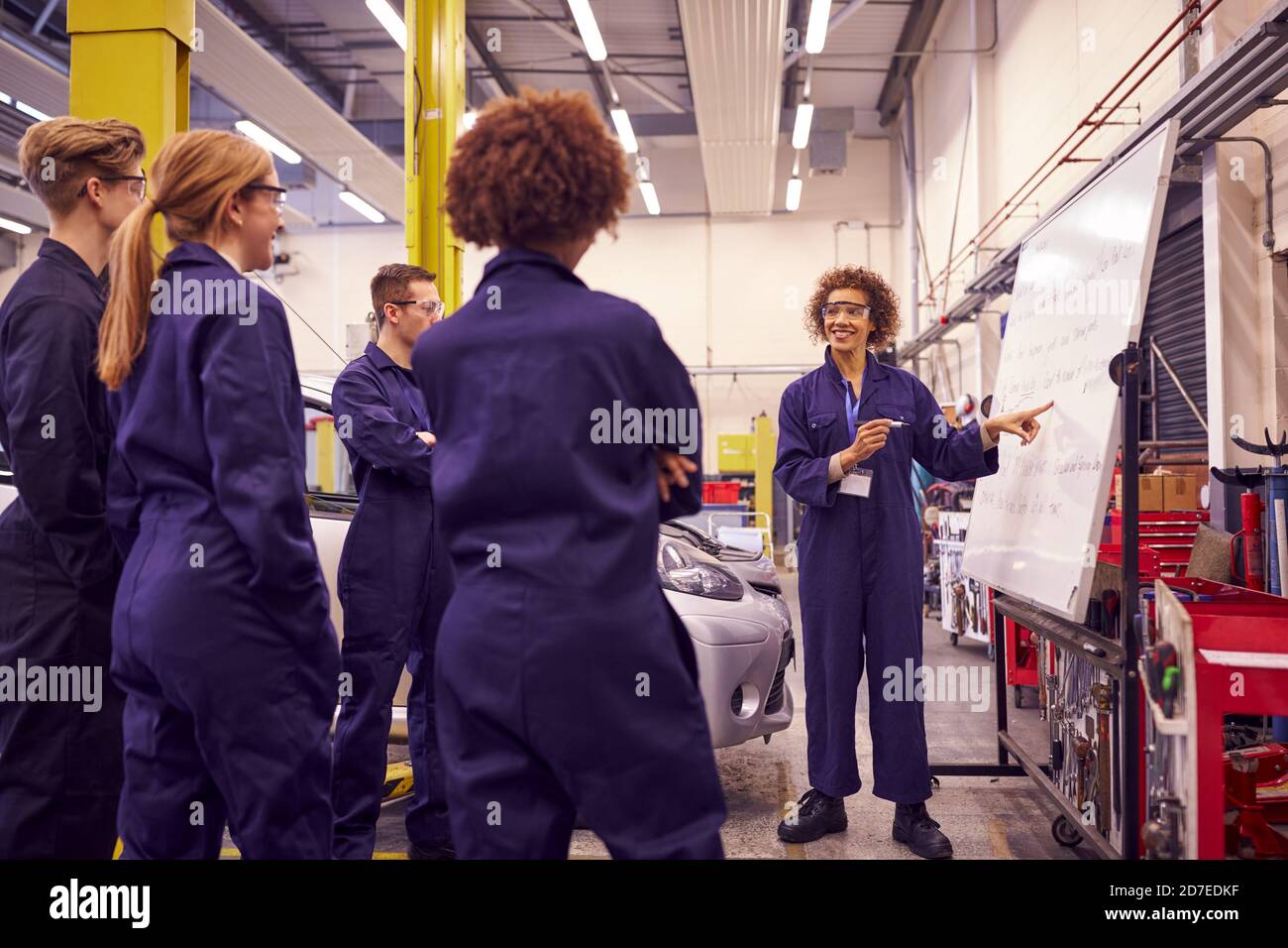 Female Tutor By Whiteboard With Students Teaching Auto Mechanic ...