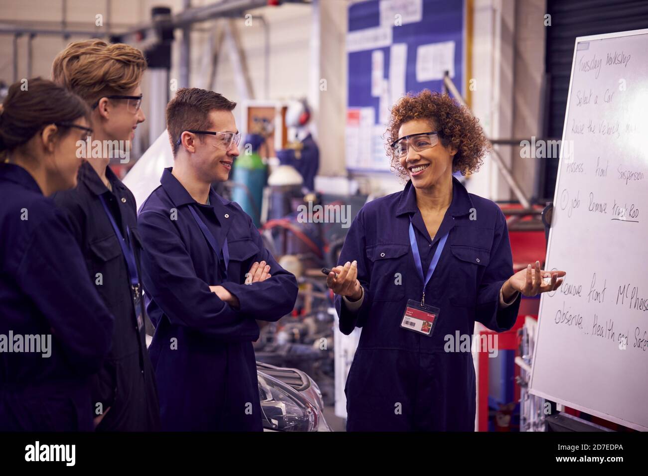 Female Tutor By Whiteboard With Students Teaching Auto Mechanic ...