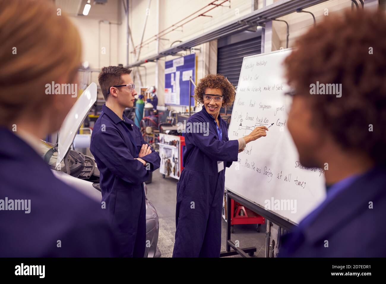 Female Tutor By Whiteboard With Students Teaching Auto Mechanic ...