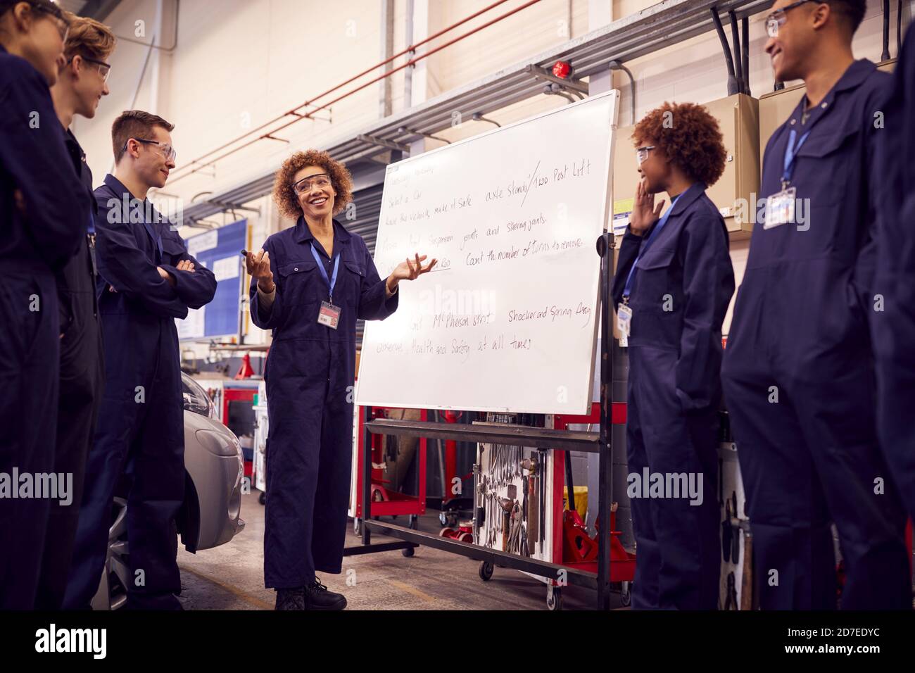 Female Tutor By Whiteboard With Students Teaching Auto Mechanic ...