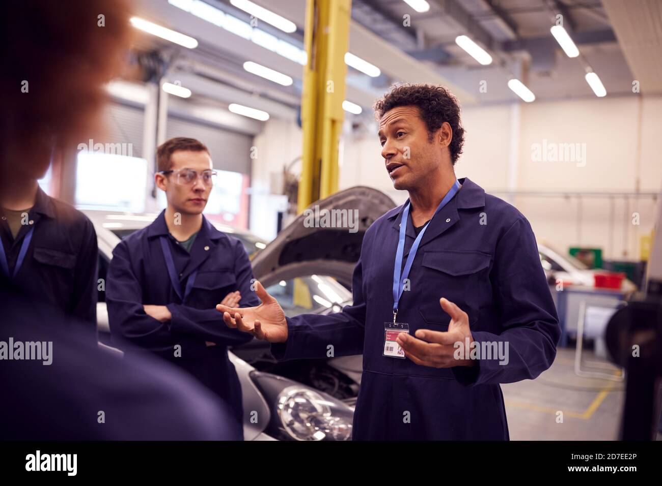Male Tutor With Students Teaching Auto Mechanic Apprenticeship At ...