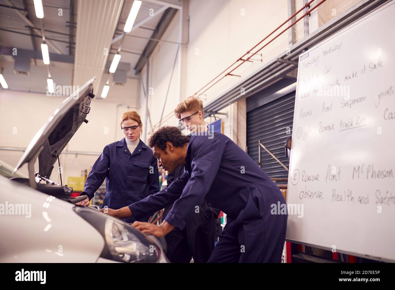 Male Tutor With Students Looking At Car Engine On Auto Mechanic ...