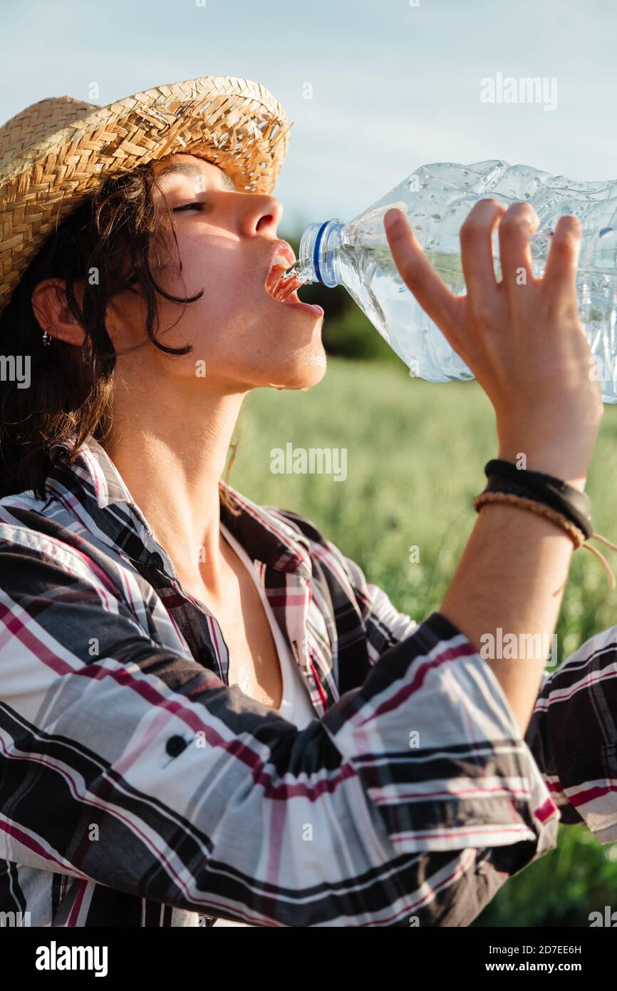 Farmer woman drinking water from plastic bottle during harvesting Stock ...