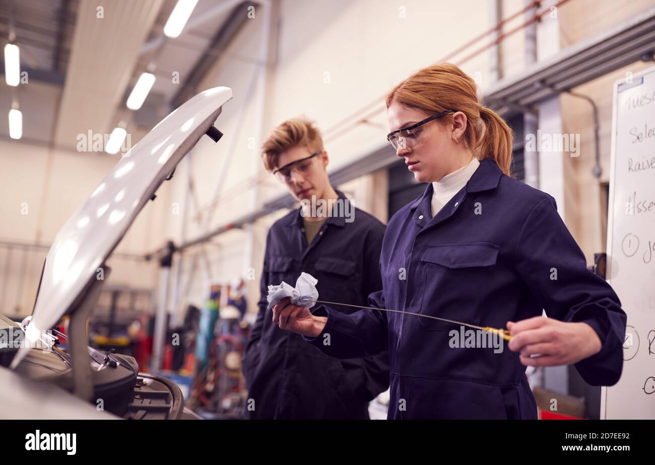 Male And Female Students Checking Car Oil Level On Auto Mechanic ...