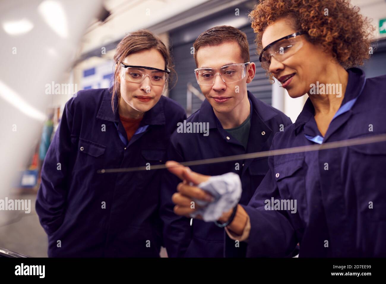 Female Tutor With Students Checking Oil Level In Car Engine On Auto ...