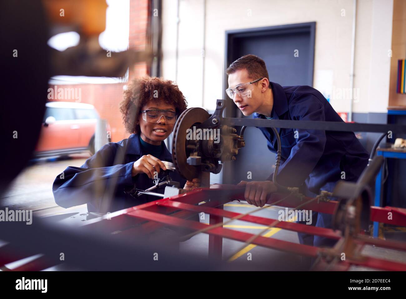 Male And Female Students Working On Car Brakes On Auto Mechanic ...