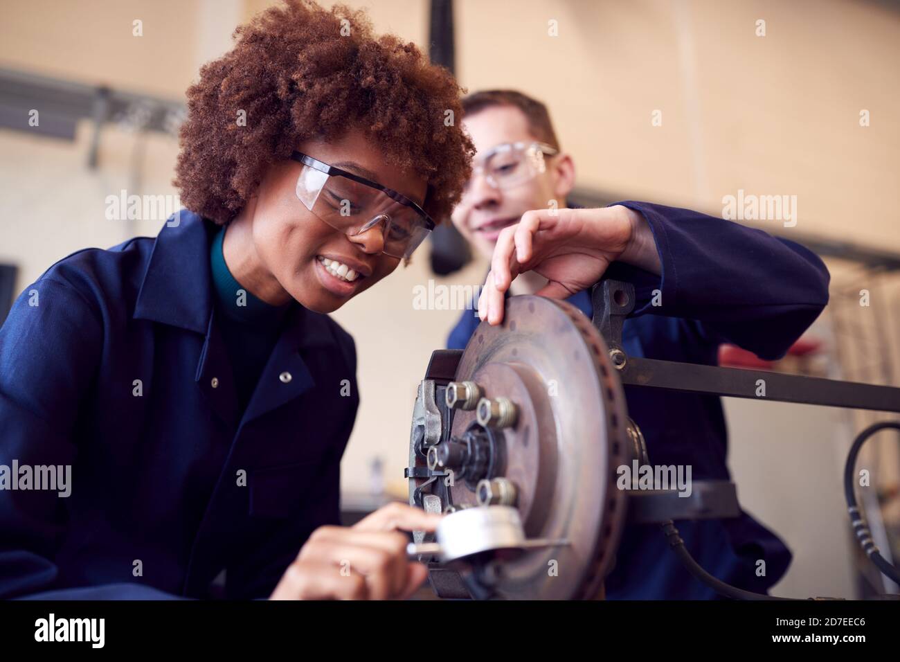 Male And Female Students Working On Car Brakes On Auto Mechanic ...