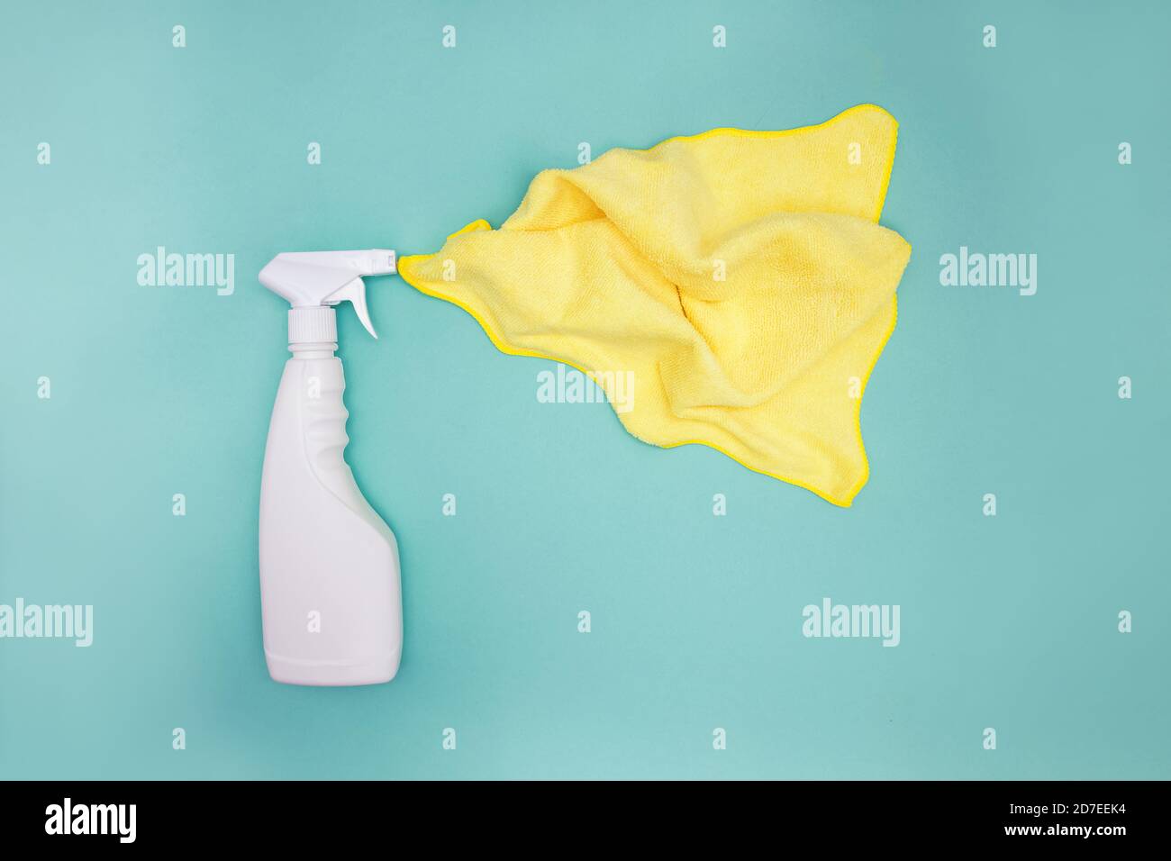 White spray plastic bottle of cleaner on green background with yellow ...