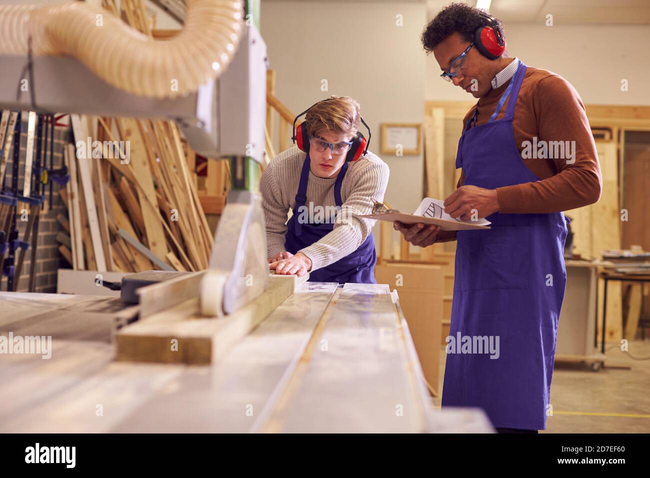 Tutor With Male Carpentry Student In Workshop Studying For ...
