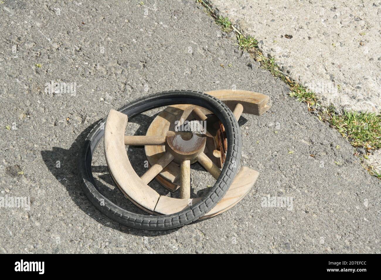 A broken wooden wheel lying on street Stock Photo - Alamy
