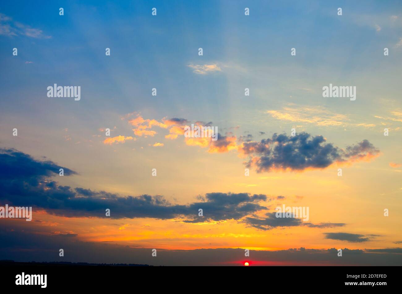 Beautiful colorful sunset sky background with the light of sun behind ...