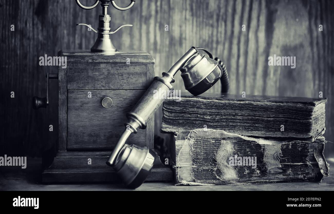 Old telephone and retro book on the desk. The phone of the past on an ...